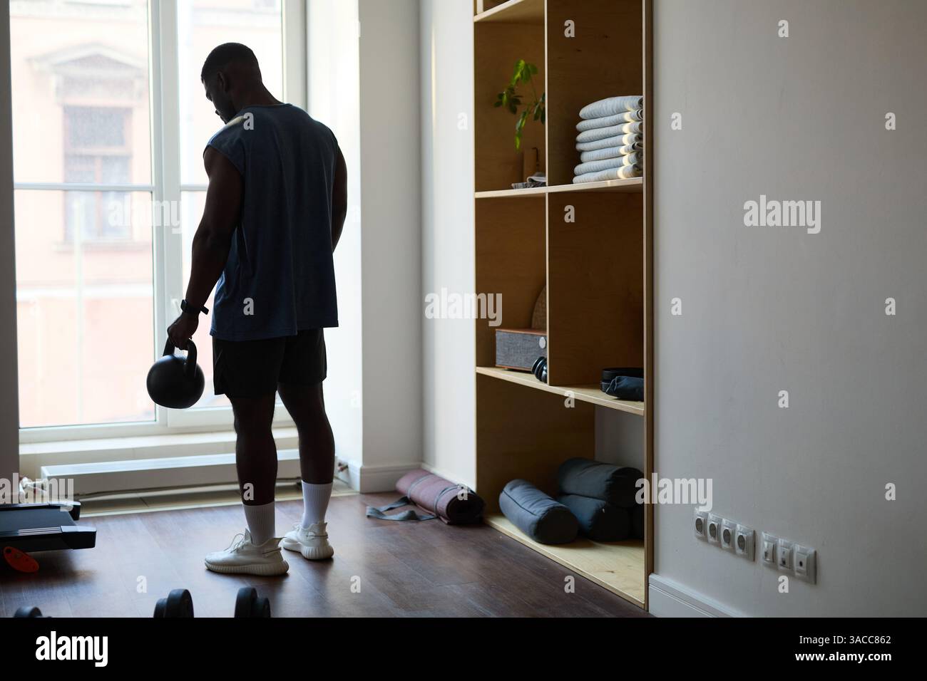 Exercising with Kettlebell in Home Gym Setting Near Window Stock Photo ...
