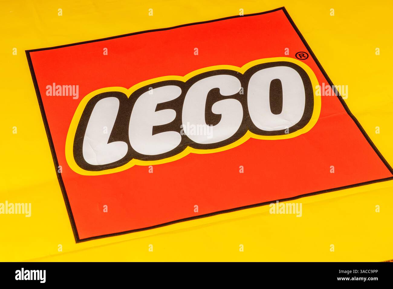 A vibrant yellow background displays a bold building blocks logo in red ...