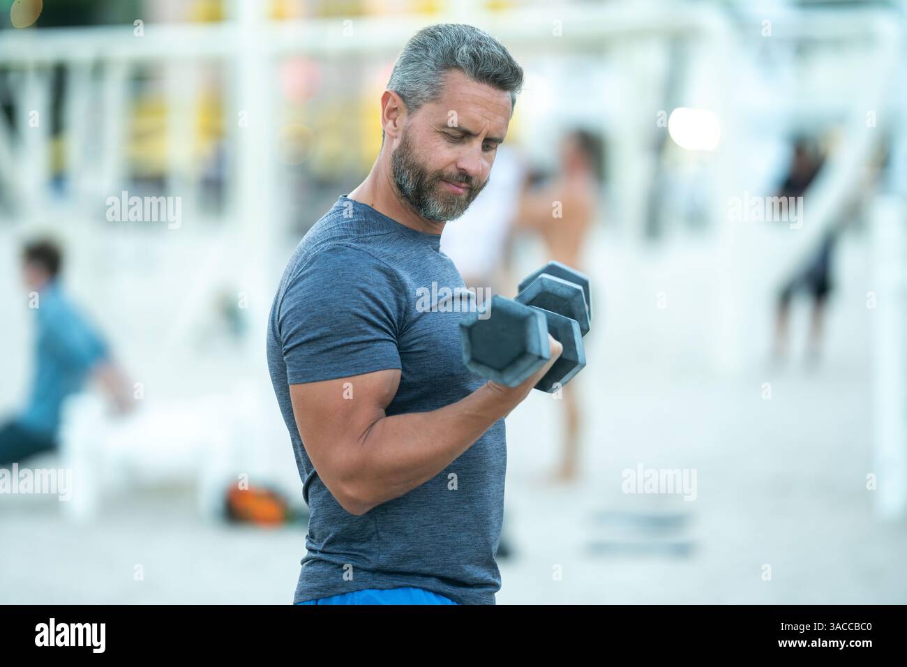 Sporty man lifting dumbbells outdoors. Sport man exercising with ...