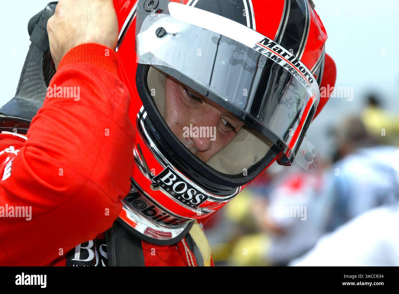 Helio Castroneves (BRA) Team Penske straps on his helmet and HANS ...