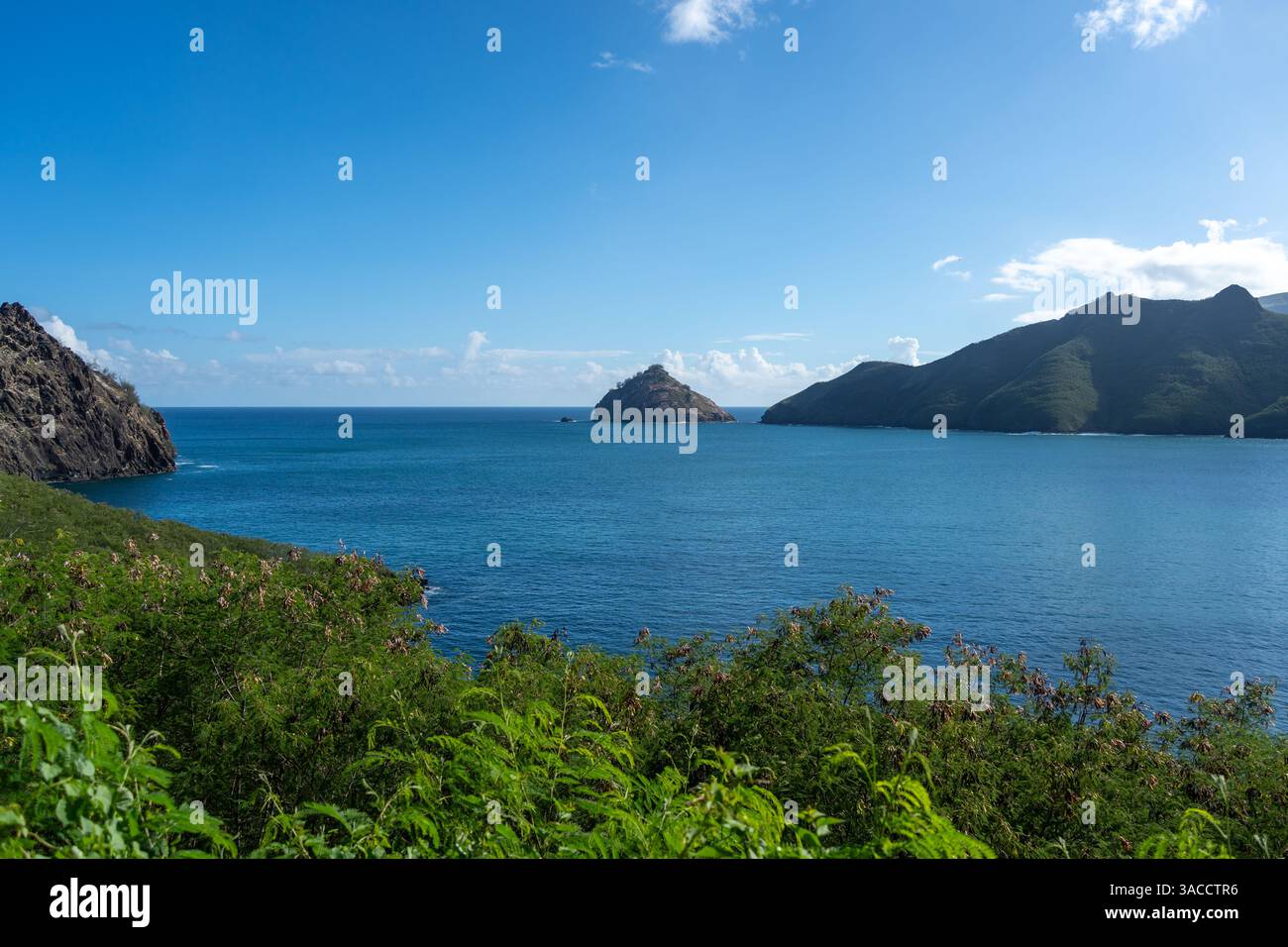 The rugged cliffs of Taiohae Bay in Nuku Hiva, Marquesas Islands, drop ...