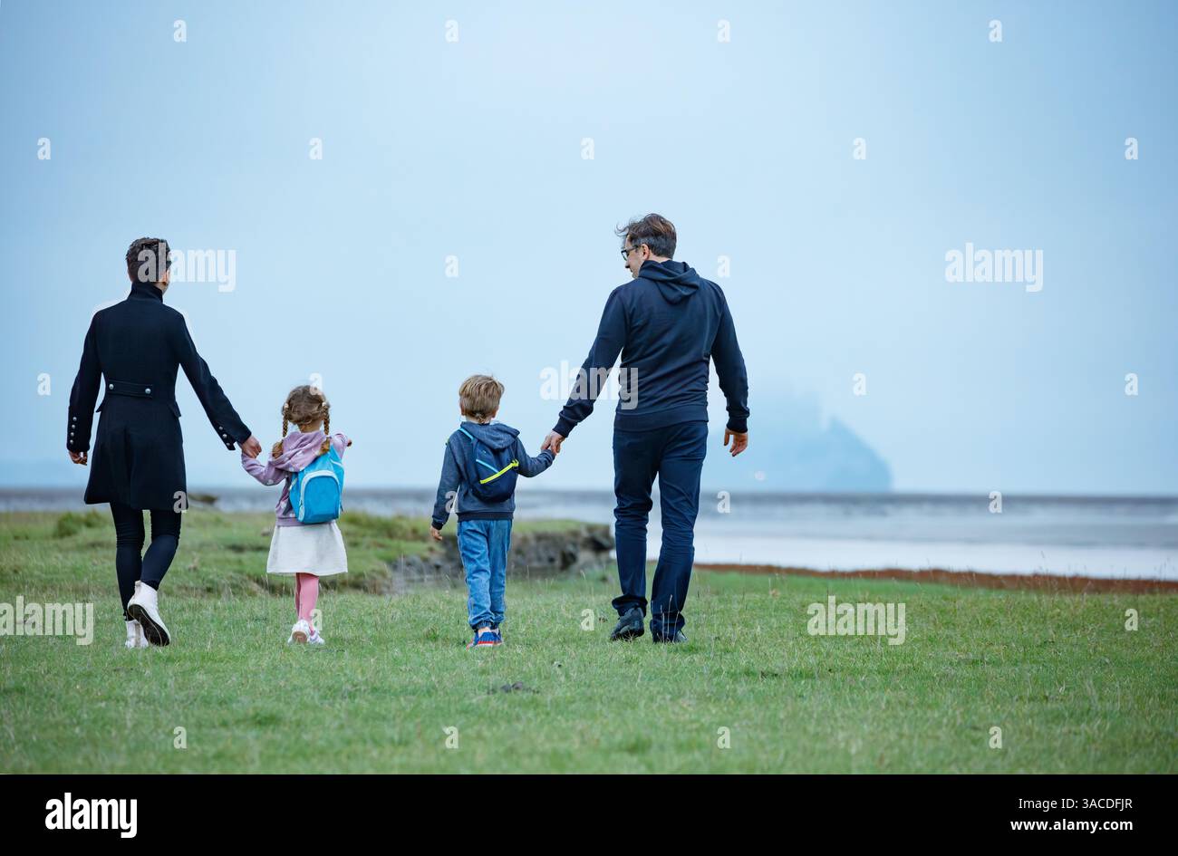 Family of travelers walk with famous castle in the mist ahead Stock ...