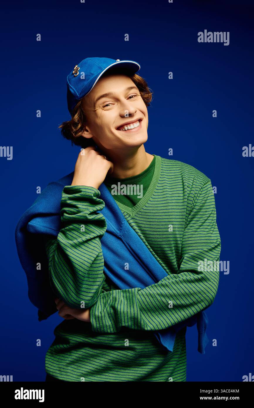 A young man in trendy attire smiles, embodying modern fashion and youth ...