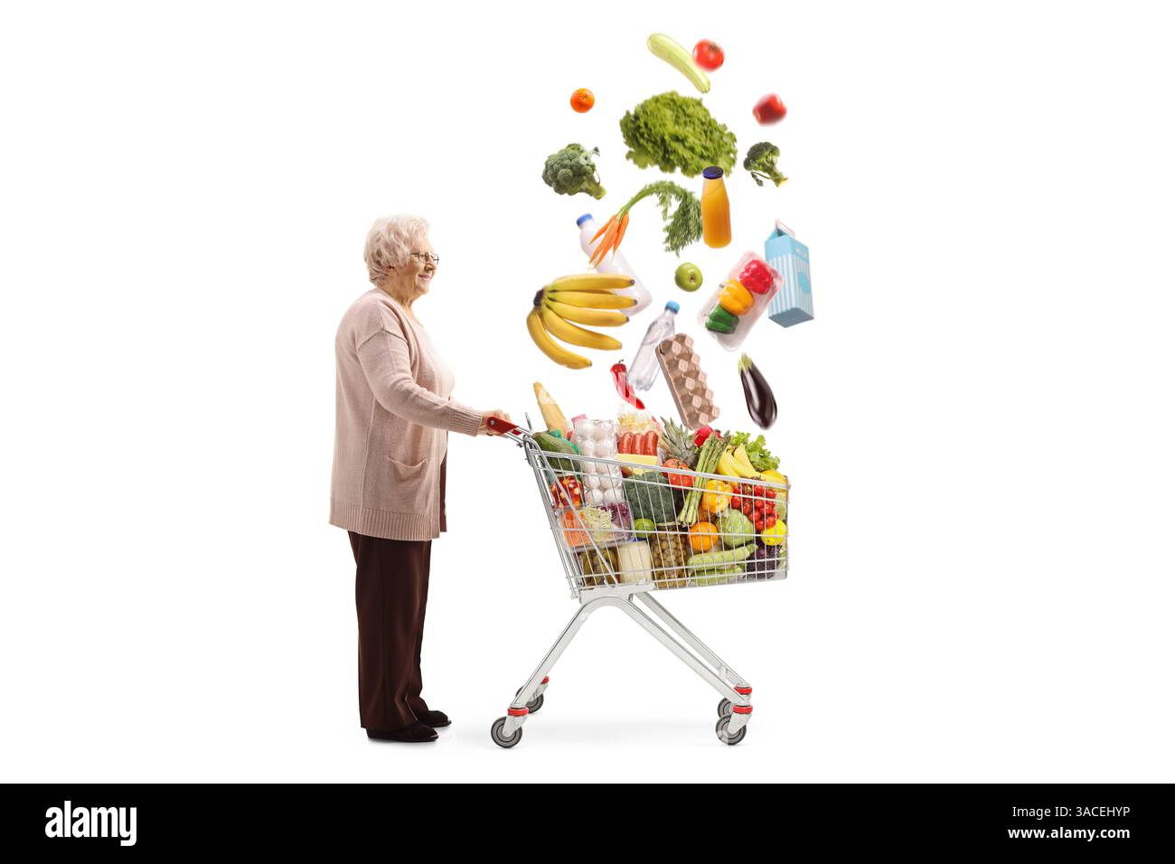 Elderly lady with a shopping cart full of falling food assortment ...