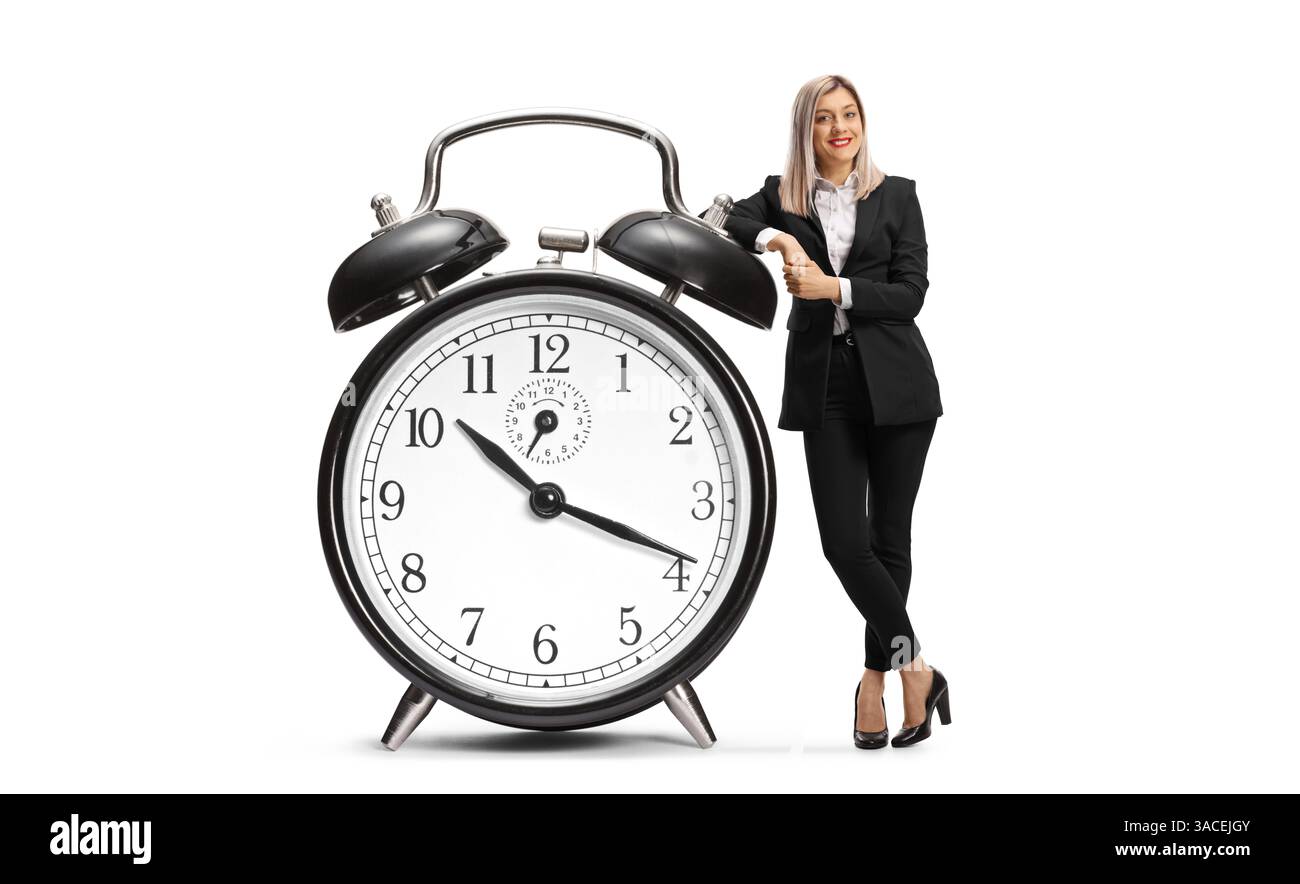 Full length portrait of a professional woman leaning on a big alarm ...