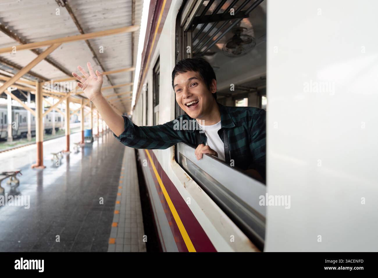 Waving Goodbye from the Train. A traveler waves from the train window ...