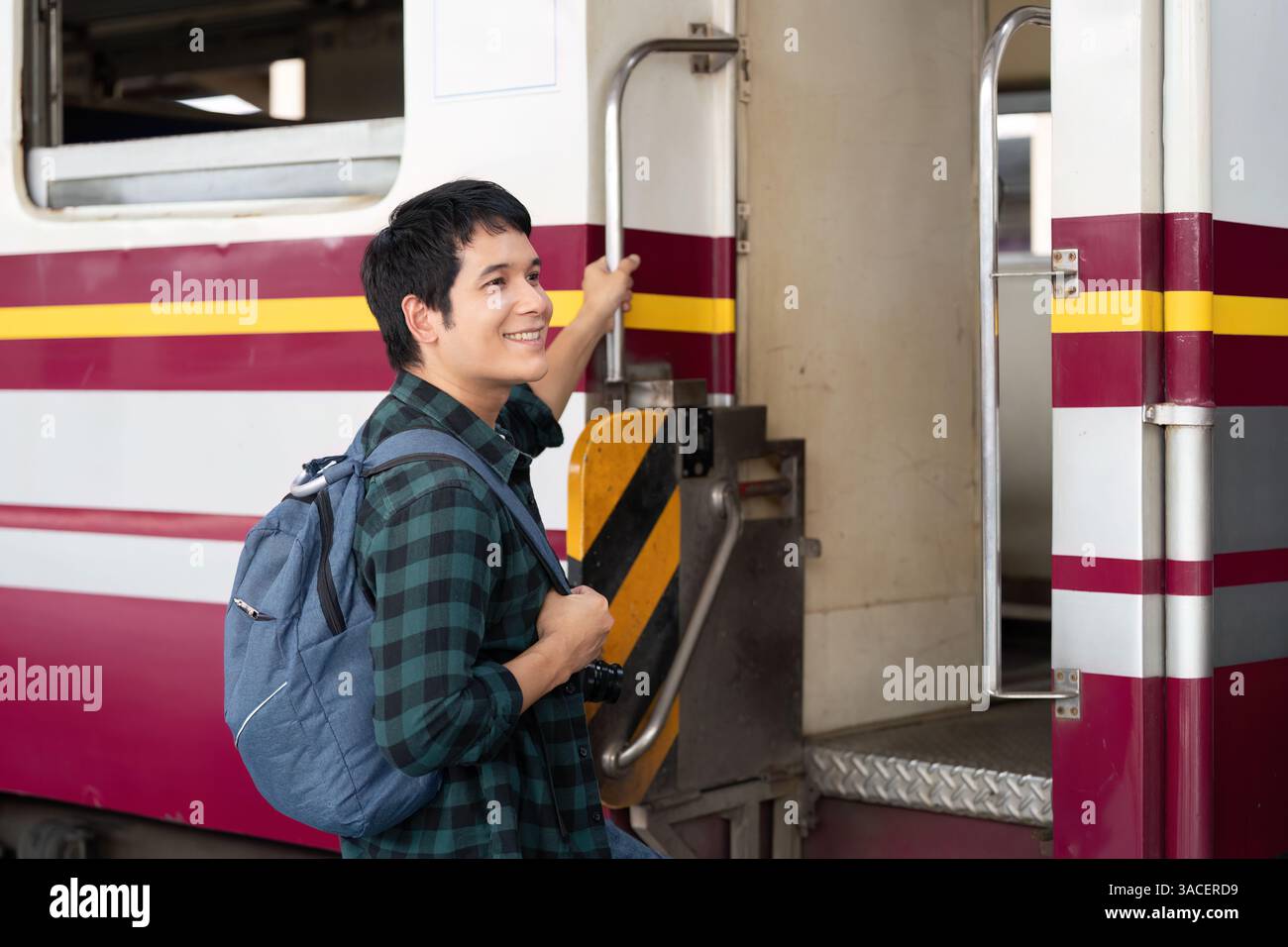 Happiness and Boarding a Train. A young man smiling while preparing to ...