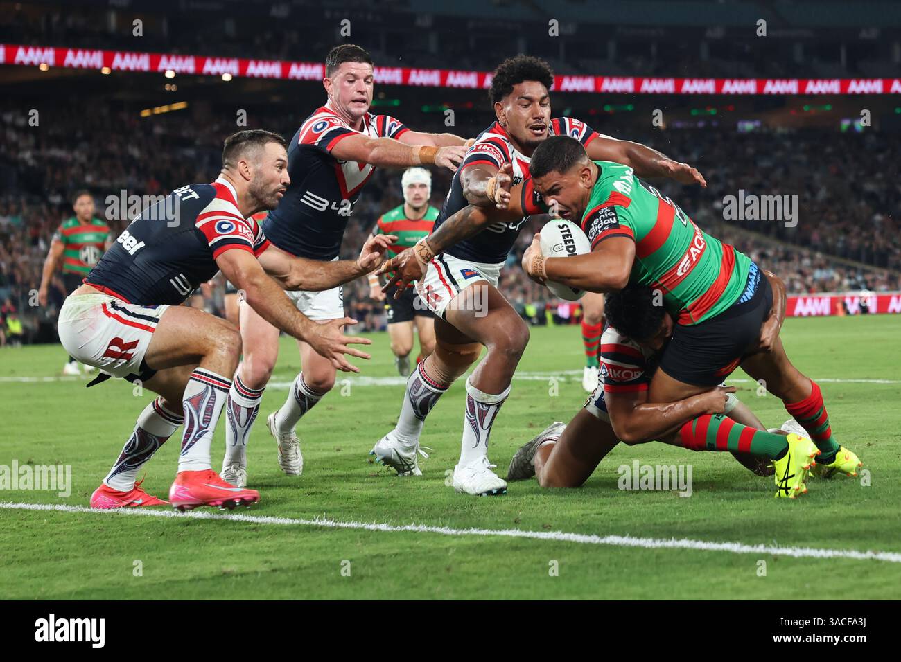 Latrell Mitchell of the Rabbitohs is tackled as he heads to the try ...
