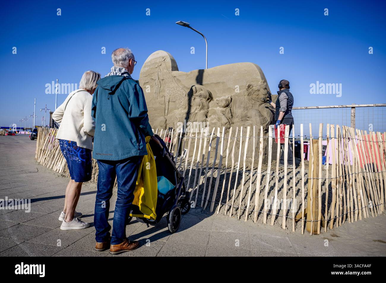 DEN HAAG - A maker works on a sand sculpture on Scheveningen's ...