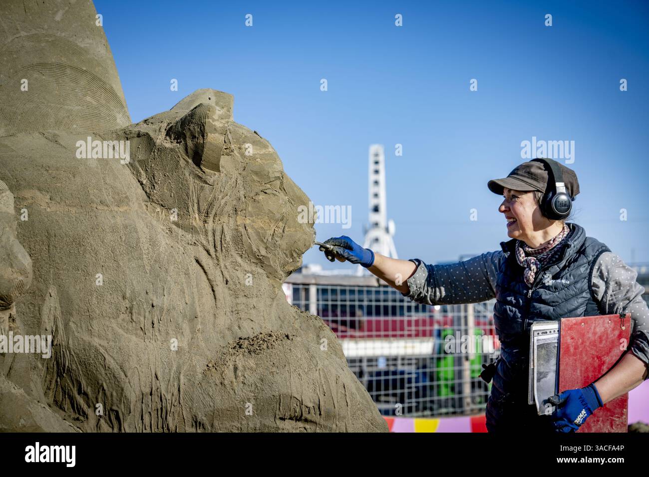 DEN HAAG - A maker works on a sand sculpture on Scheveningen's ...