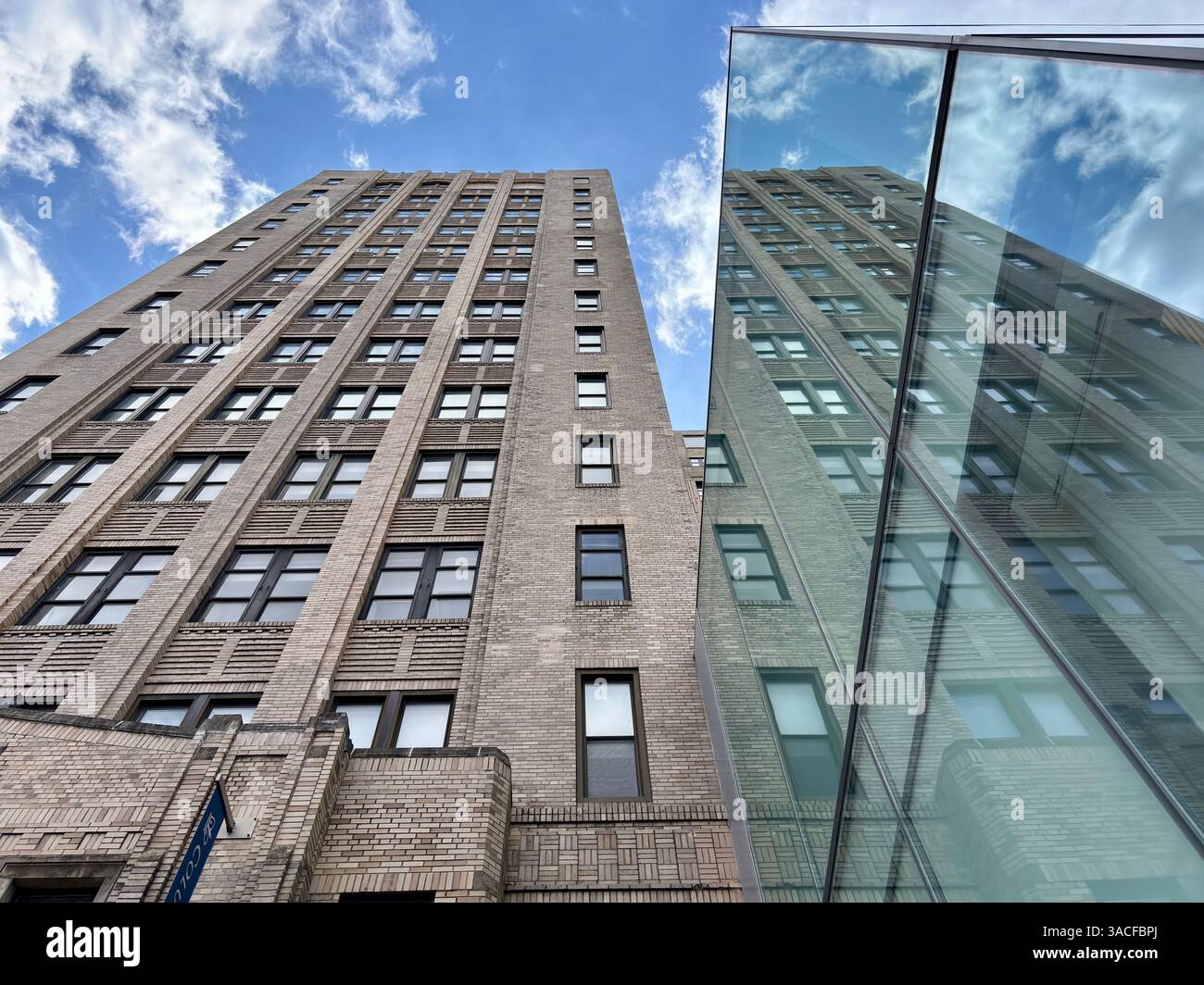 Brick building reflected in glass structure beneath blue sky Stock ...