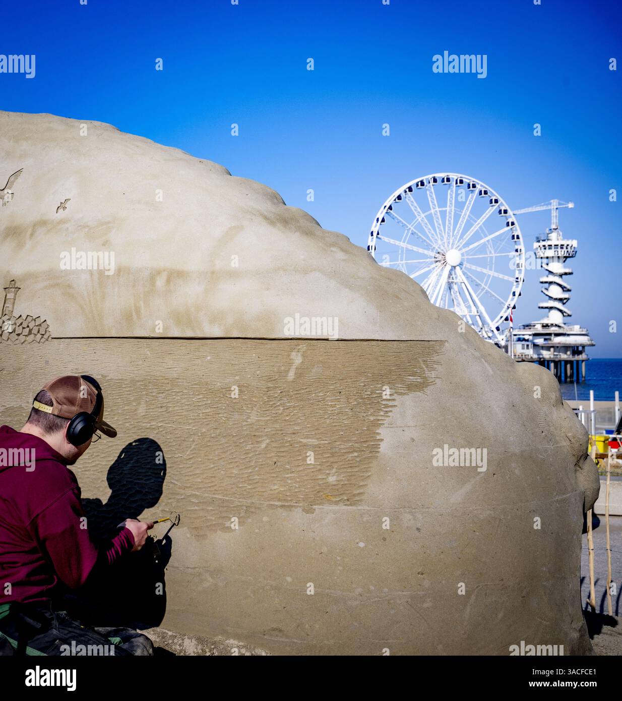 DEN HAAG - A maker works on a sand sculpture on Scheveningen's ...