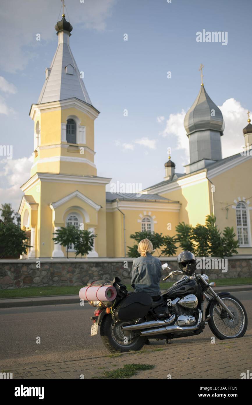Female Traveler Resting by a Church on a Motorcycle Stock Photo - Alamy