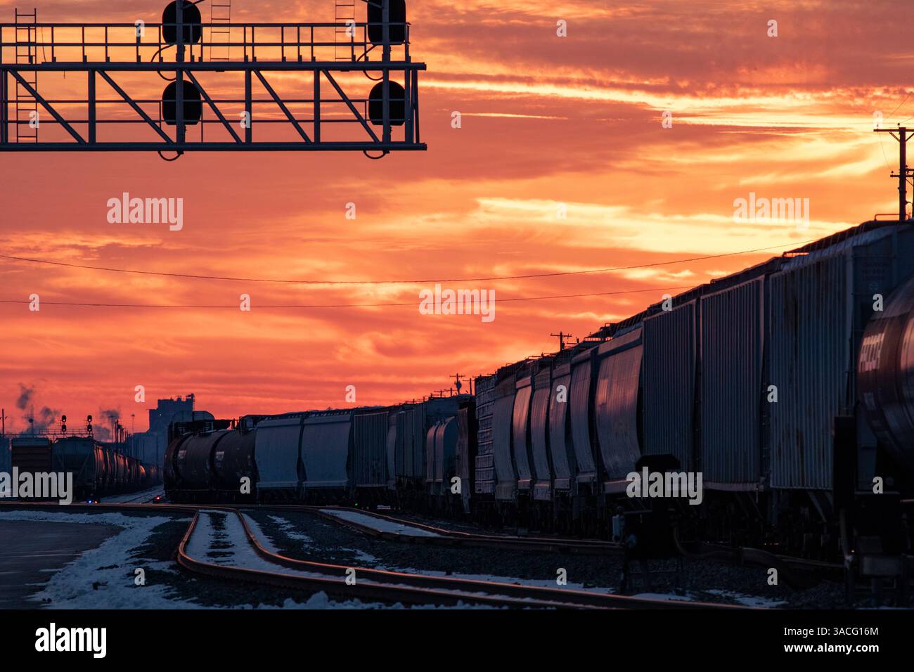 A train in a train yard under fiery sunset Stock Photo - Alamy
