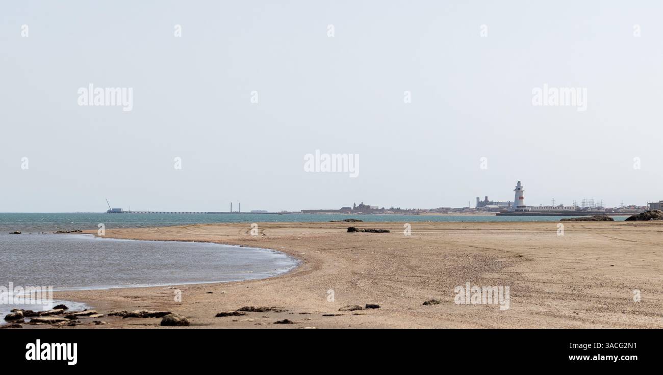 Serene coastal scene portraying an expansive sandy shore, calm waters ...