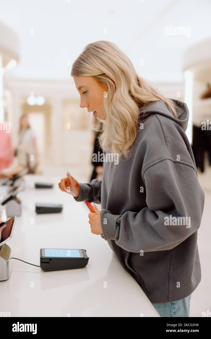 Teen girl at counter, ready to check out Stock Photo - Alamy
