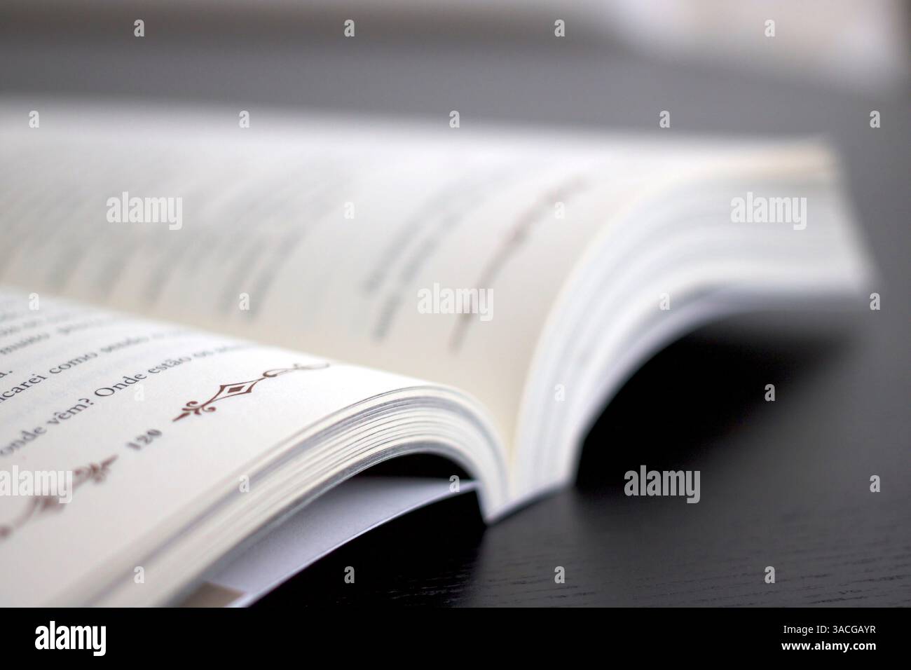 Open book with visible pages and text, captured in a well-lit setting ...