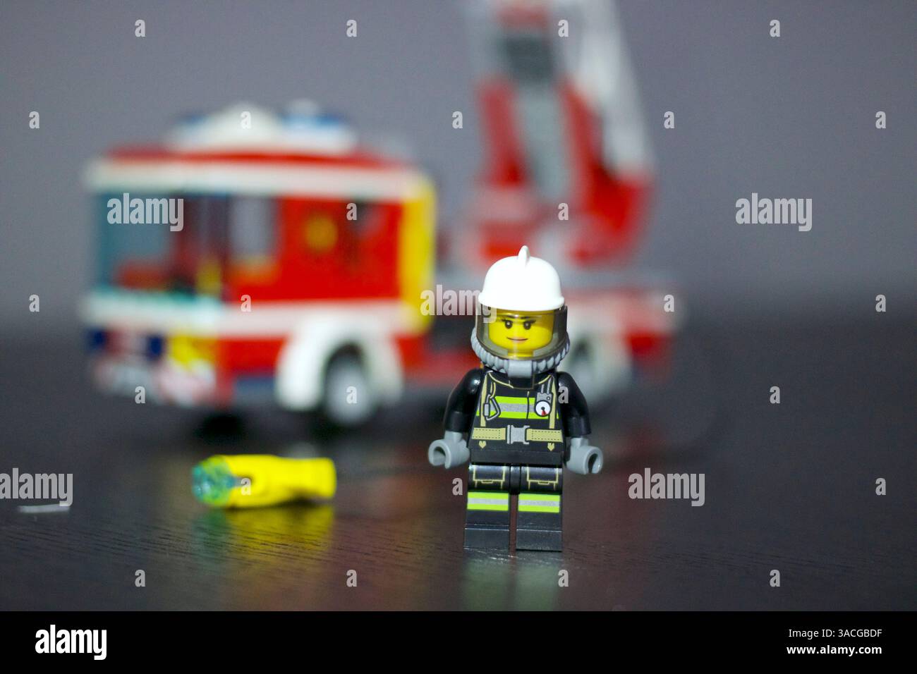 LEGO firefighter and red fire truck toy model photographed against a ...