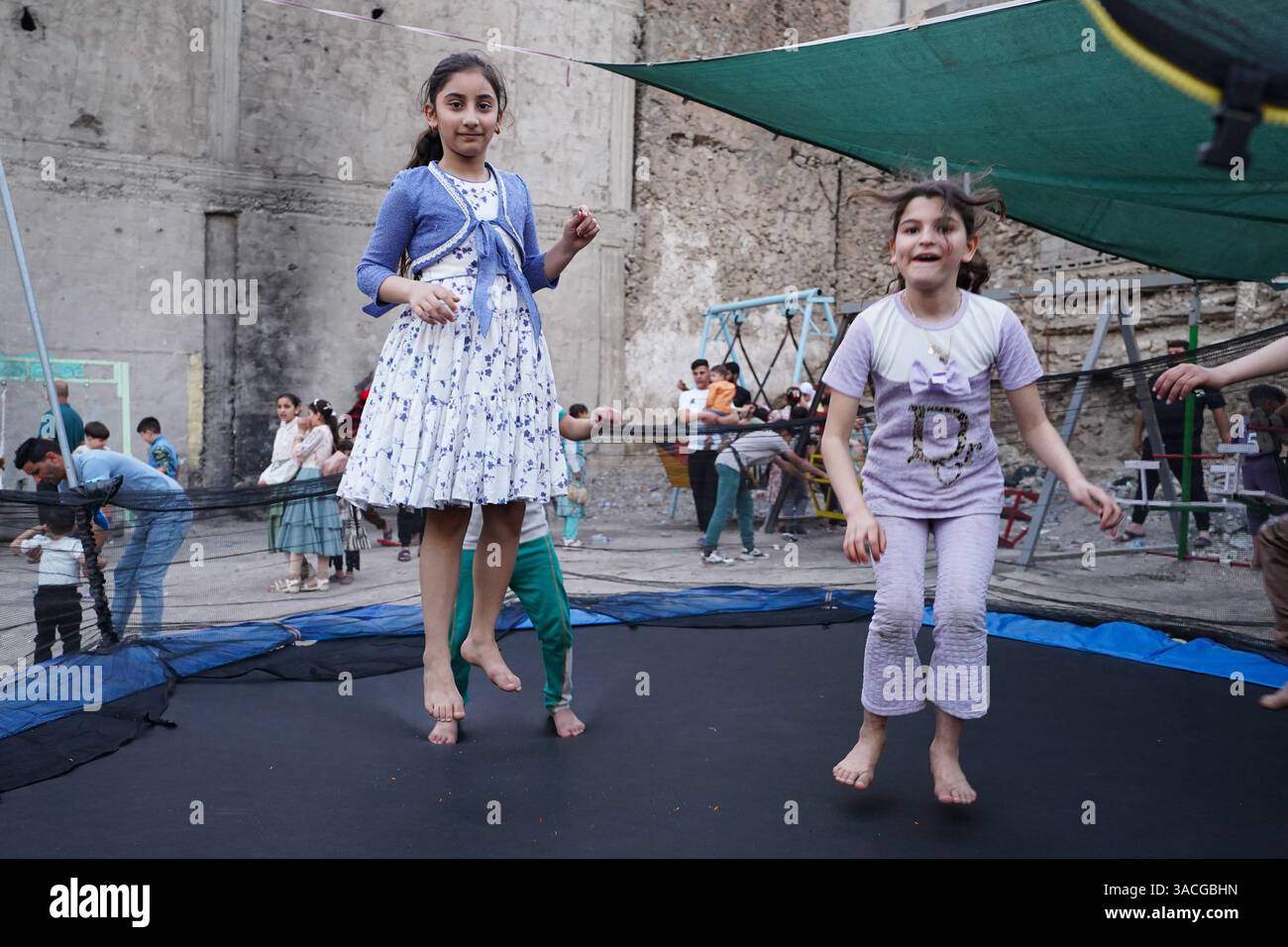 Mosul, Iraq. 02nd Apr, 2025. Iraqi children play on a trampoline at a ...