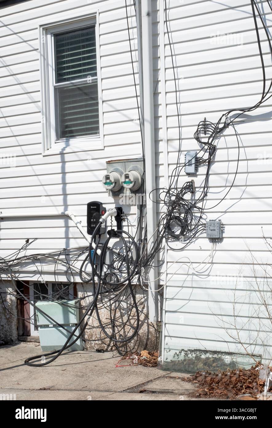 A mess of wires on the side of a private home. It appears to be ...