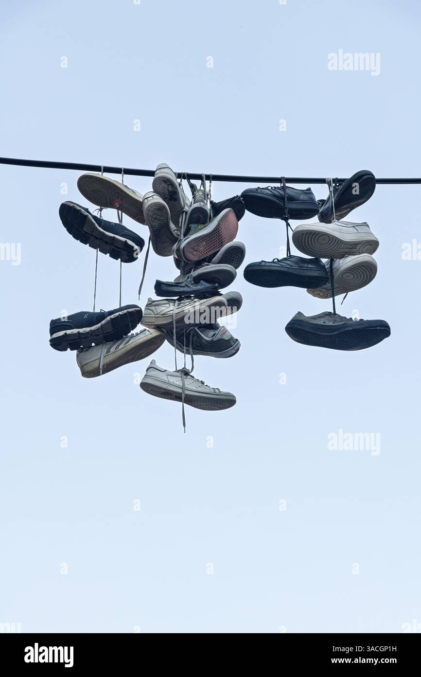 Shoes and sneakers hanging from a line in New York Stock Photo - Alamy