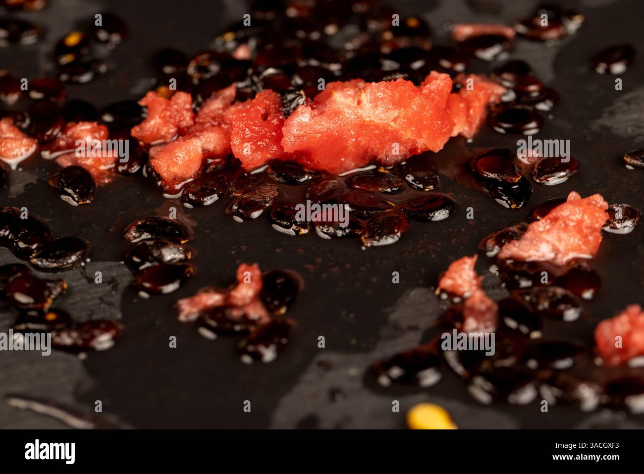watermelon seeds and red pulp on black slate, watermelon seeds after ...