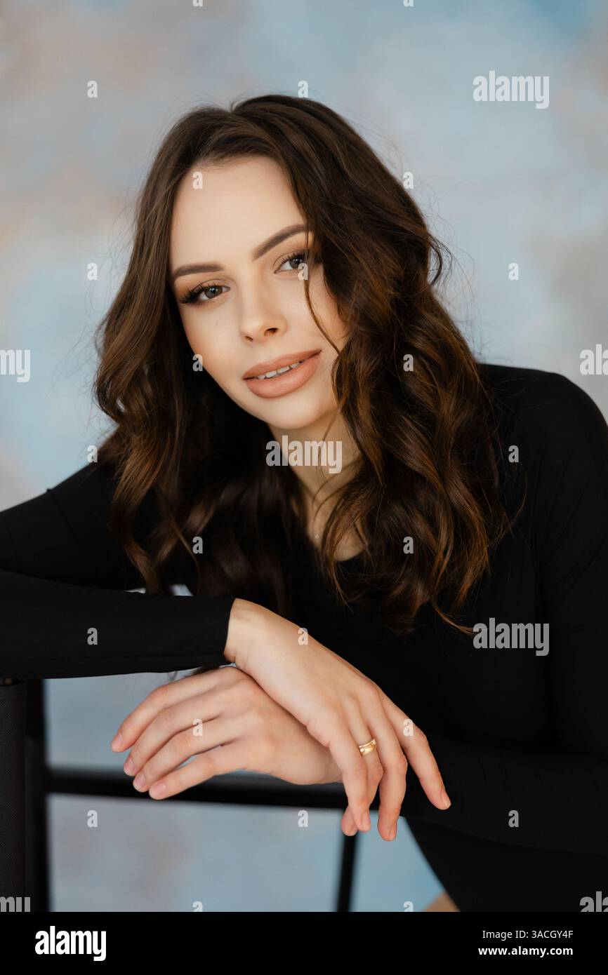 Portrait of a young woman leaning against chair hi-res stock ...