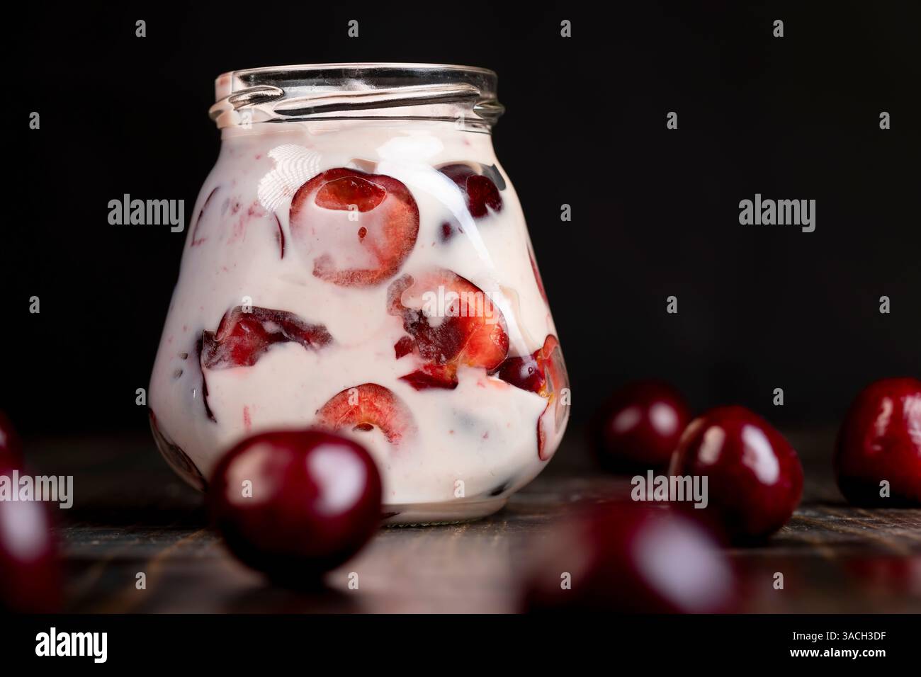 yogurt with cherry flavor and berry , glass jar with cherry yogurt with ...