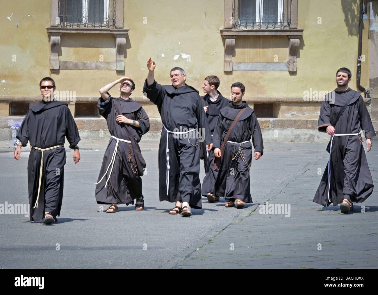 5 young Franciscan Monks in robes get a tour of Lucca, Italy guided by ...