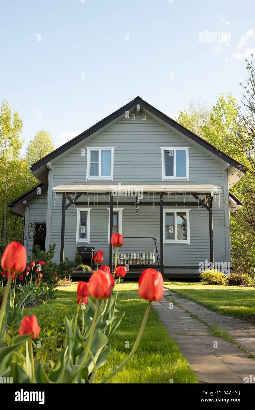 Contemporary two-story house of timber in countryside in spring ...