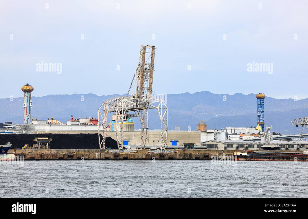 Large crane works on large coal stockpile and container at Industrial ...
