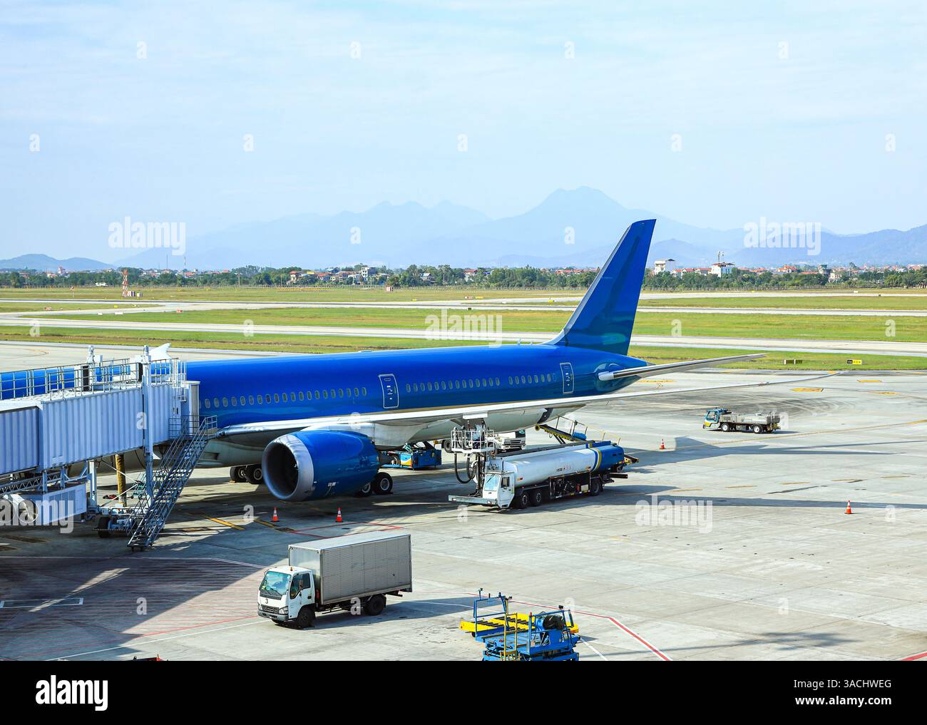 Ground Service fuel truck Refueling a blue aircraft at aircraft bay ...
