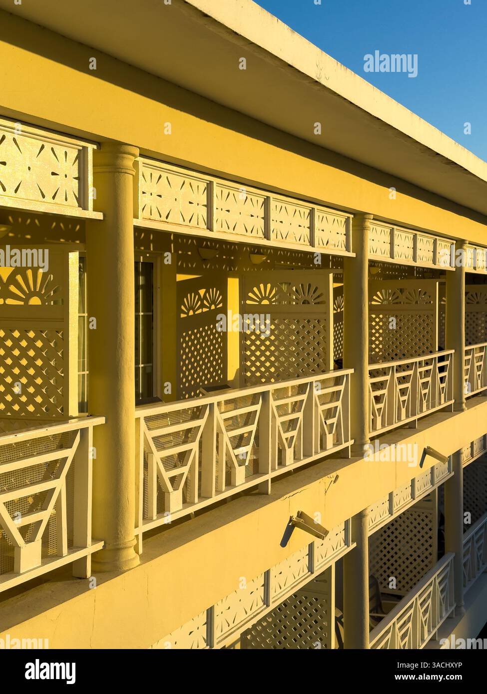 The building has a lot of white trim and a lot of windows. The windows ...