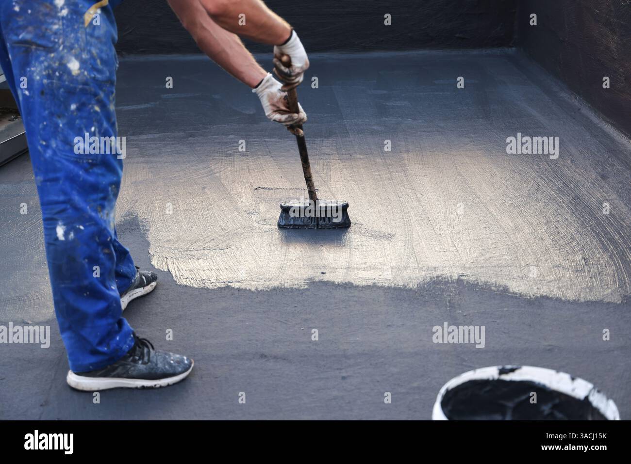 Construction worker with brush applying waterproofing layer coating on ...
