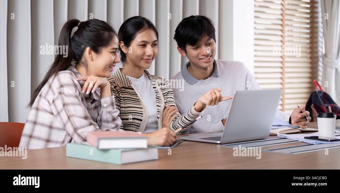 Teamwork and Learning. Three students collaborating on a project using ...