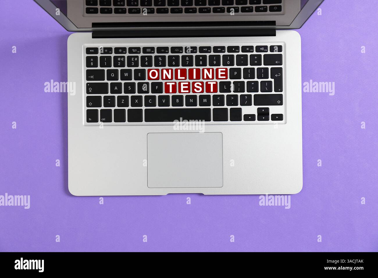 Online test. Laptop keyboard with buttons making words on violet ...