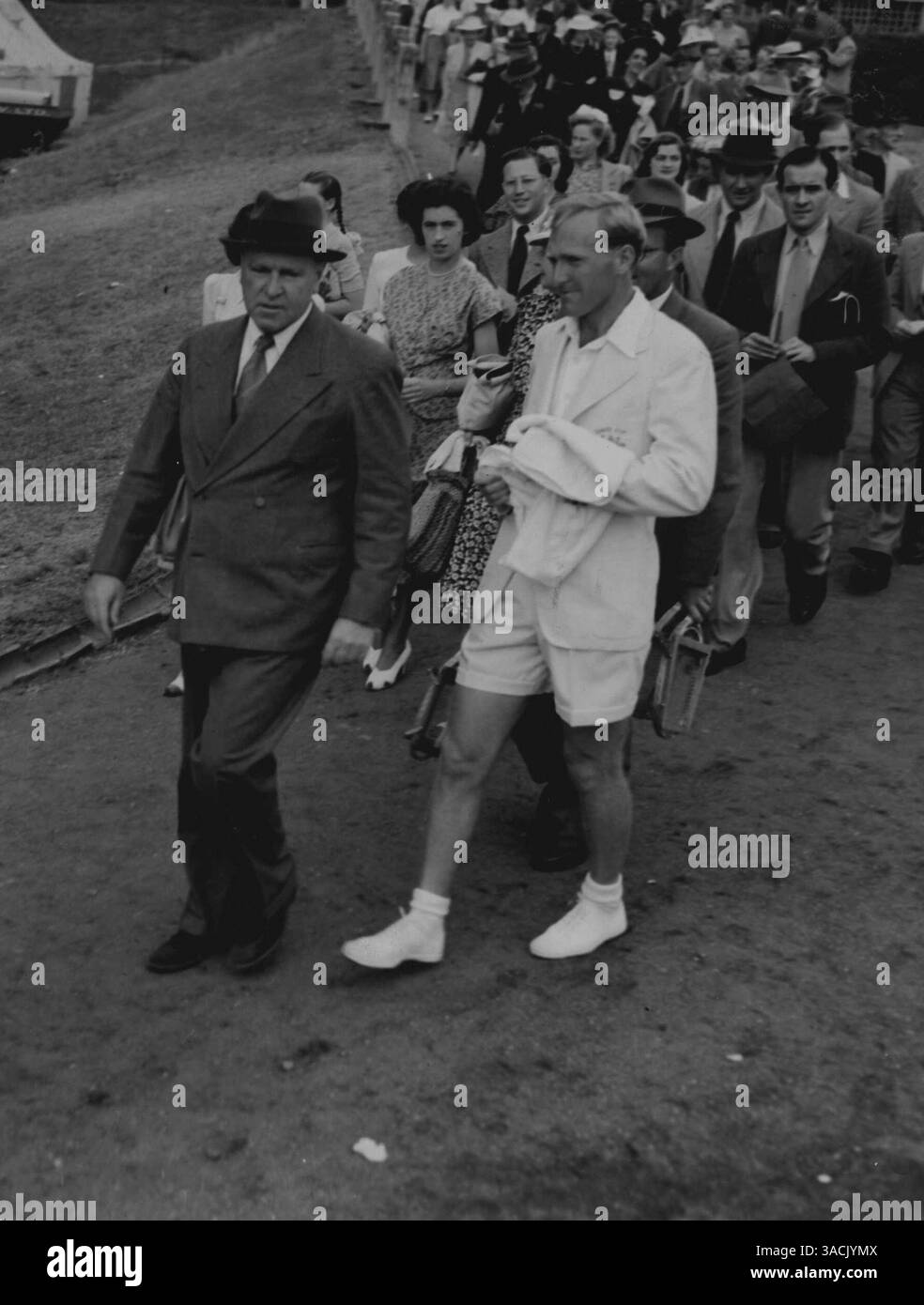 Crowd of enthusiasts follow John Bromwich as he walks to the court at ...