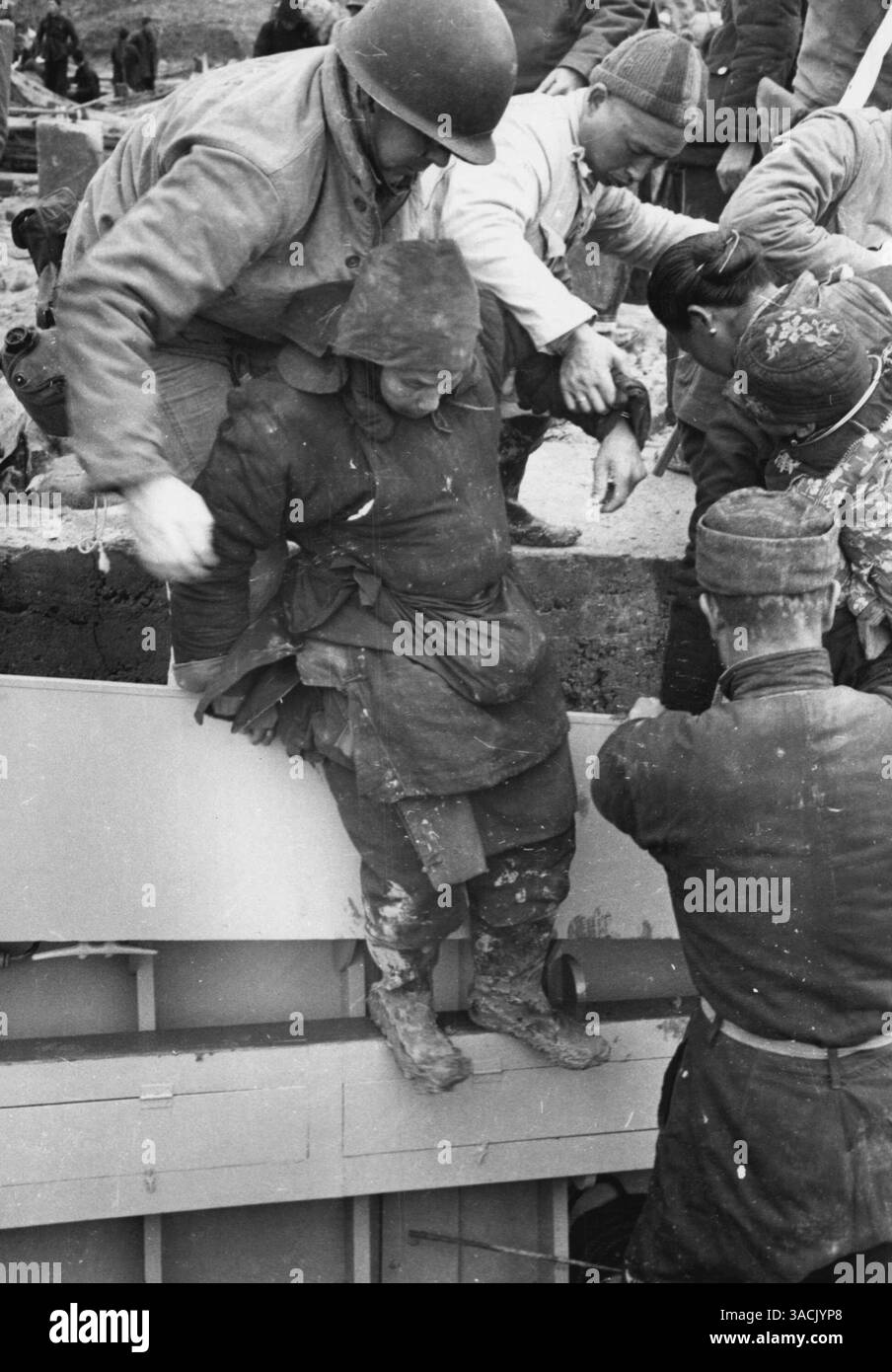 An old lady is helped into a landing craft on one of the beaches of the ...