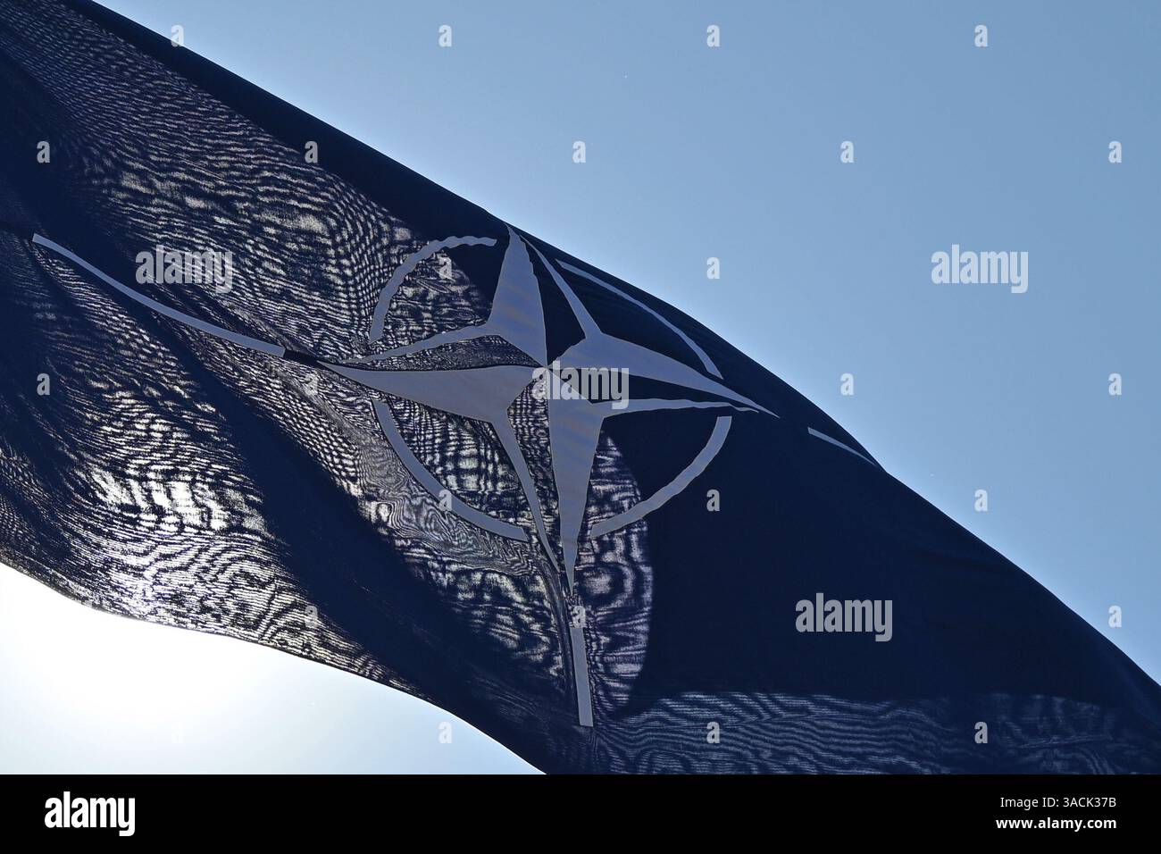 SYMBOL - 04 April 2025, Belgium, Brüssel: A NATO flag flies in the wind ...