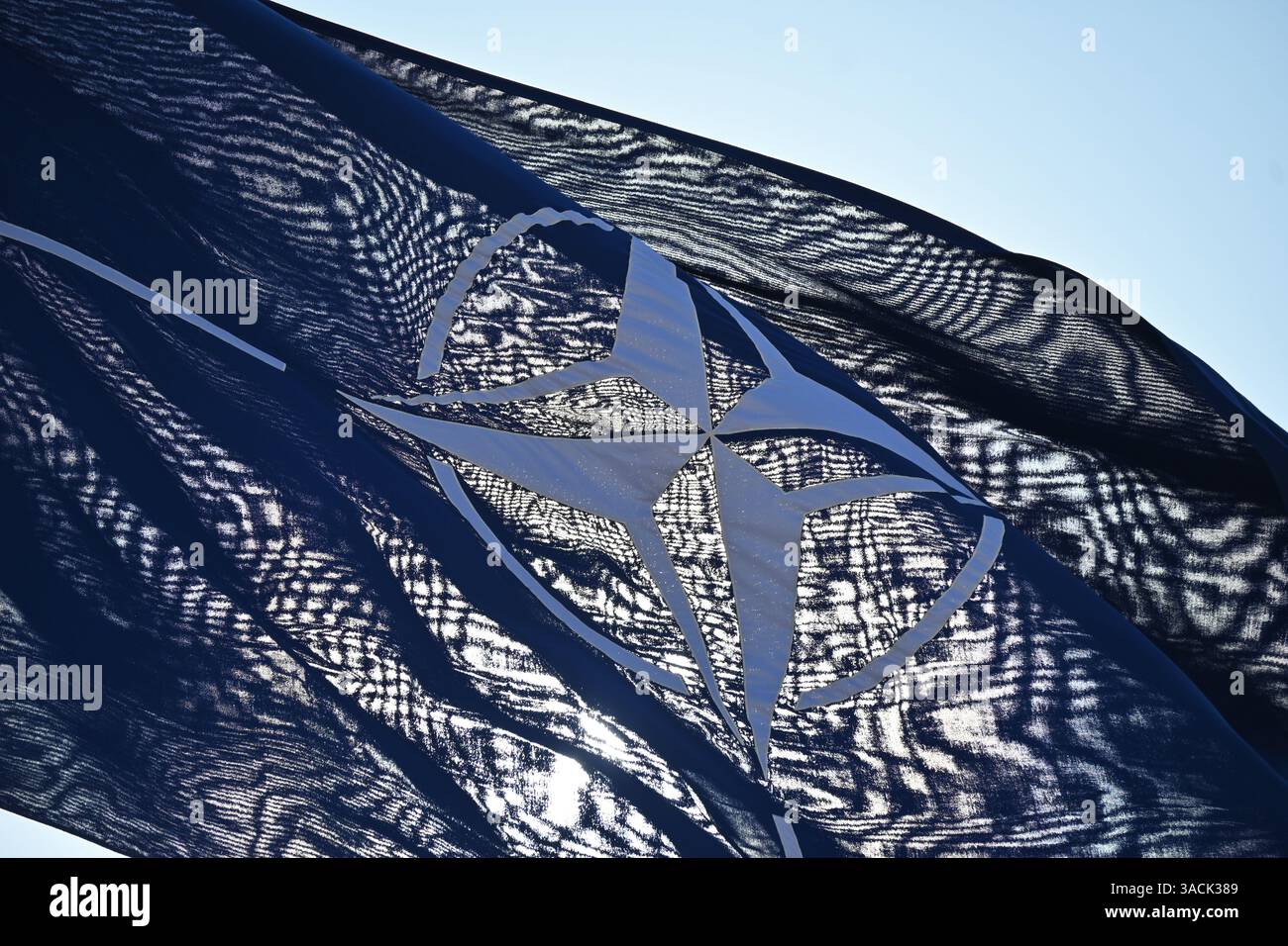 SYMBOL - 04 April 2025, Belgium, Brüssel: A NATO flag flies in the wind ...