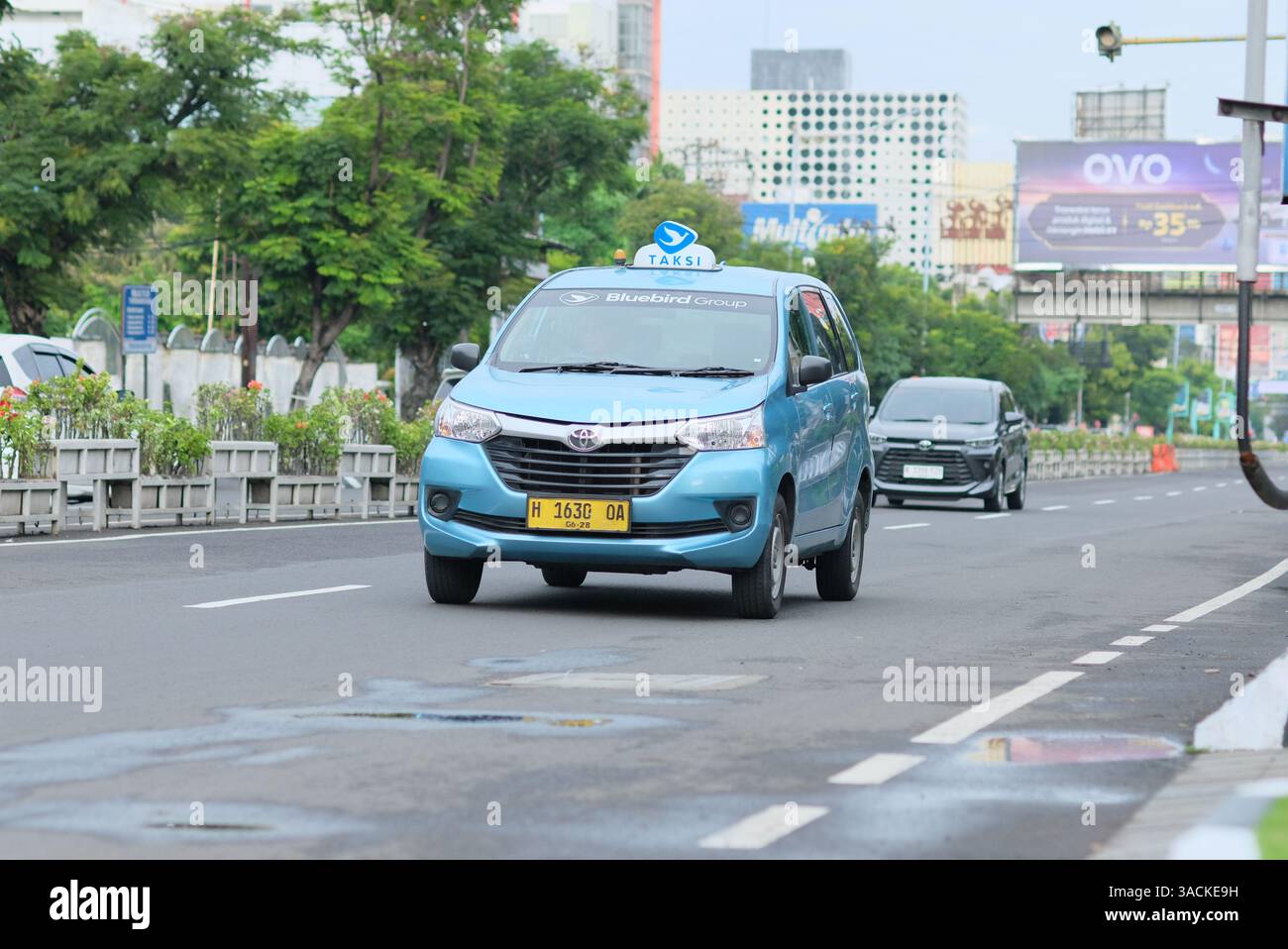 Semarang, Indonesia - 29 March 2025: Blue taxi car. The blue taxi car runs on the highway during ...