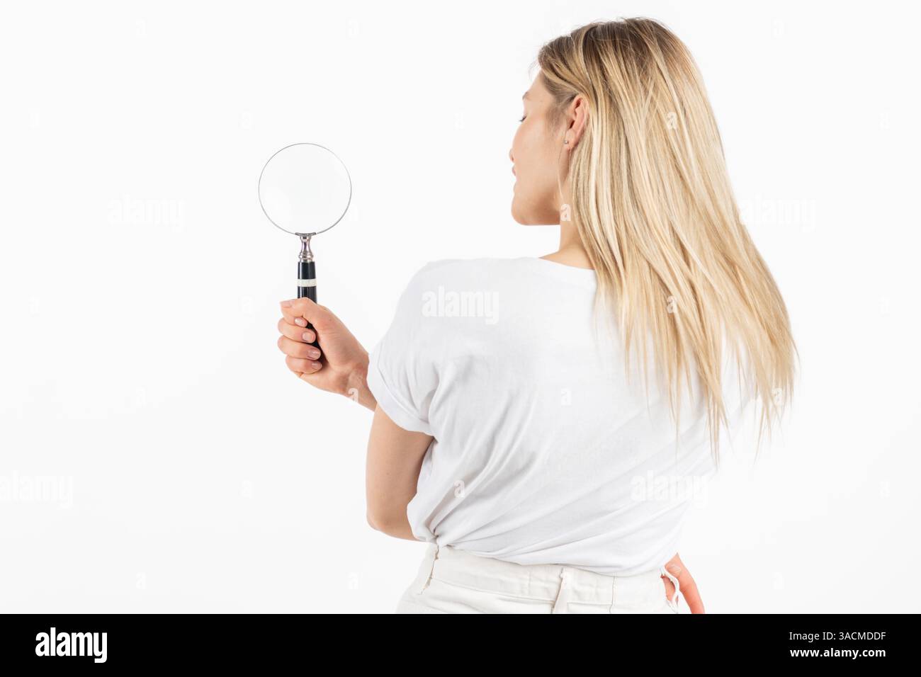 Studio portrait of woman with magnifying glass. Model with excitement ...