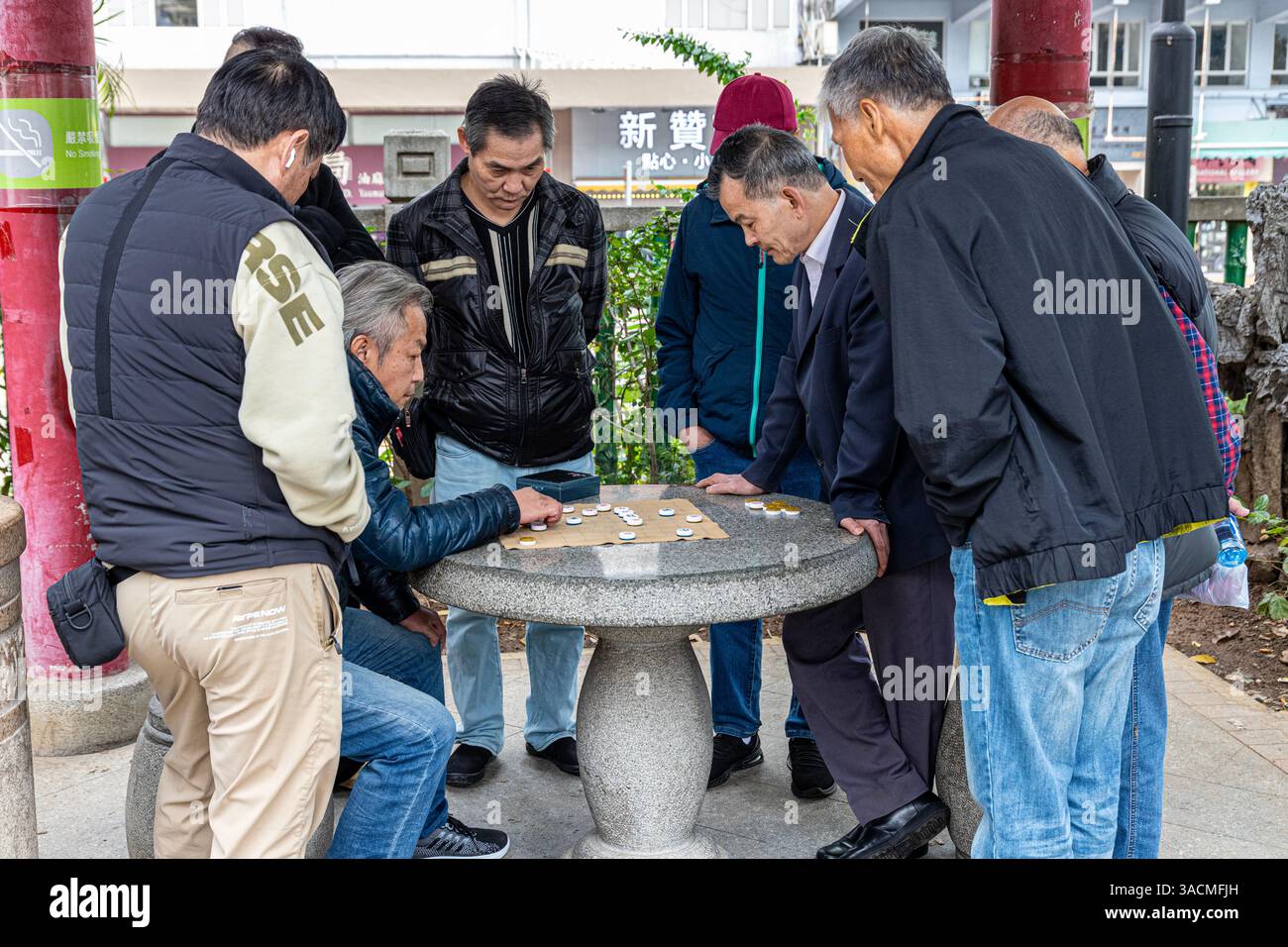 Men playing Chinese chess (xiangqi) watched by onlookers in the Public ...