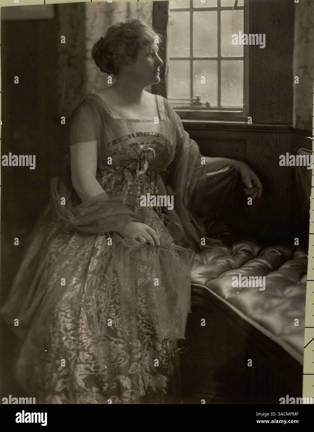 Mrs. George B. Lane is pictured in a long gown, seated on a couch and ...