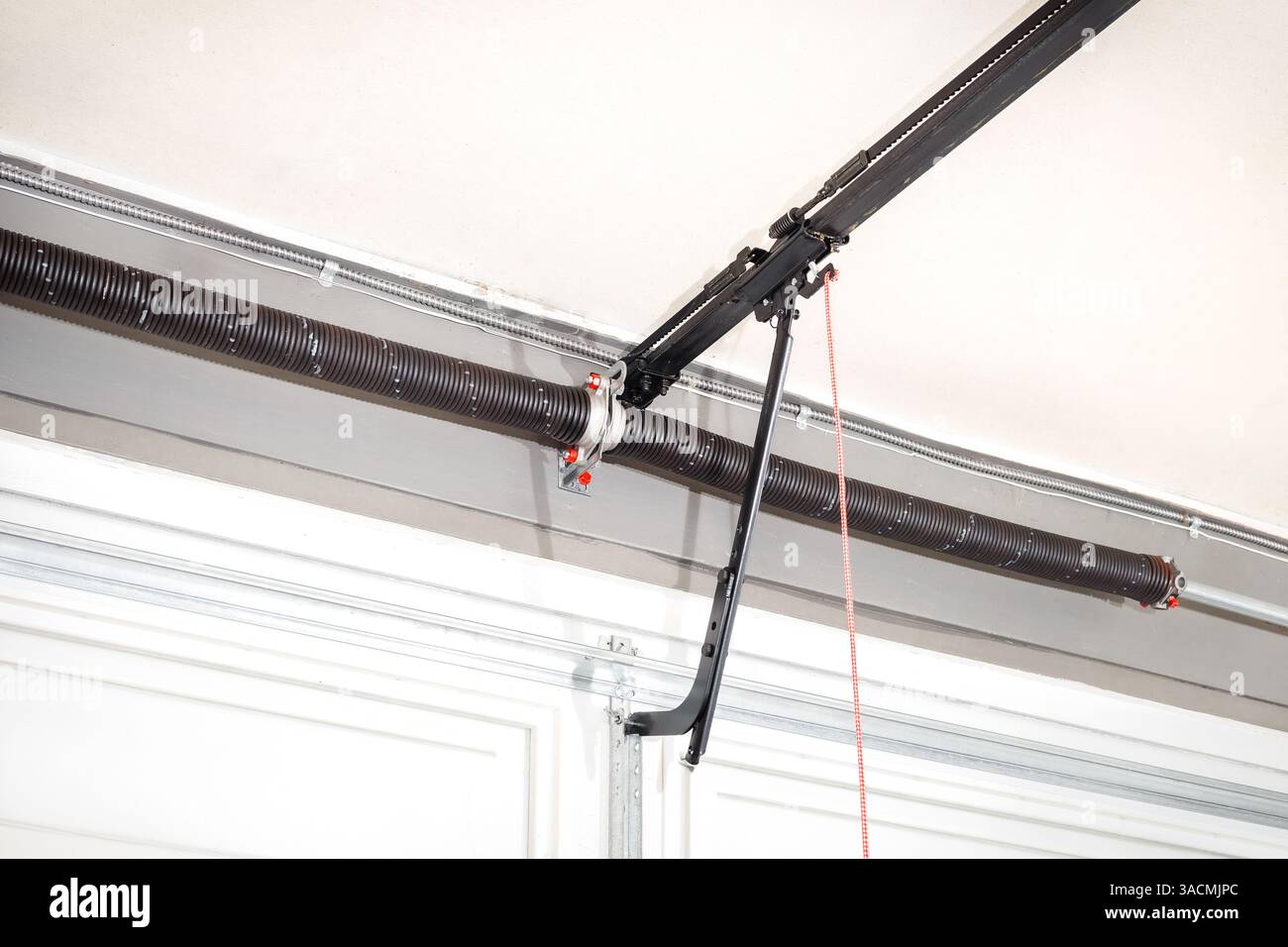 Overhead sectional door mechanism or components. Close up of torsion ...