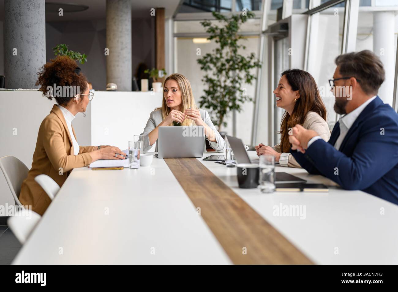 Professionals sharing ideas and discussing strategies while working on ...