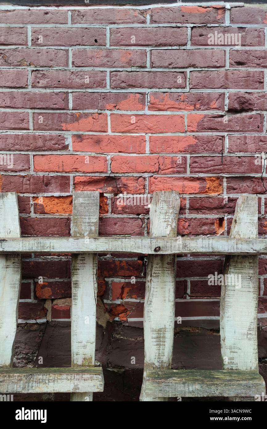 Picket fence in front of brick wall Stock Photo - Alamy
