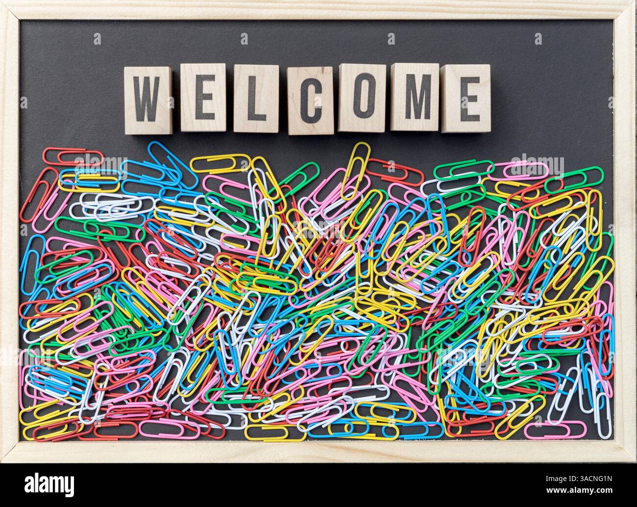 Black board with colorful paper clips and wooden cubes with the text ...