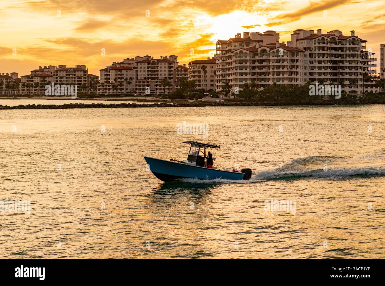 Miami canal with boat. Fisher island residential building and luxury ...