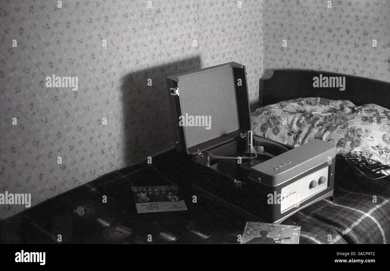 1960s, historical, a portable record player sitting on a single bed in ...